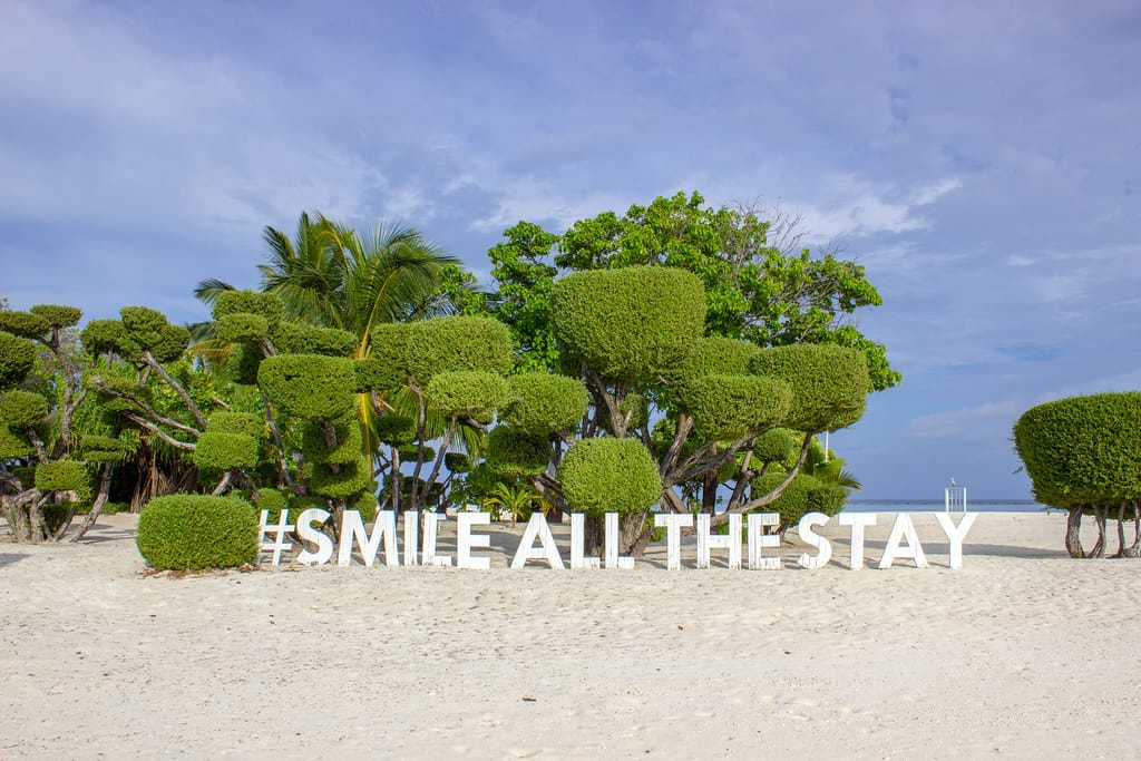 Smile All the Stay Sign Placed on the Beach with Trees Behind It Photo ...